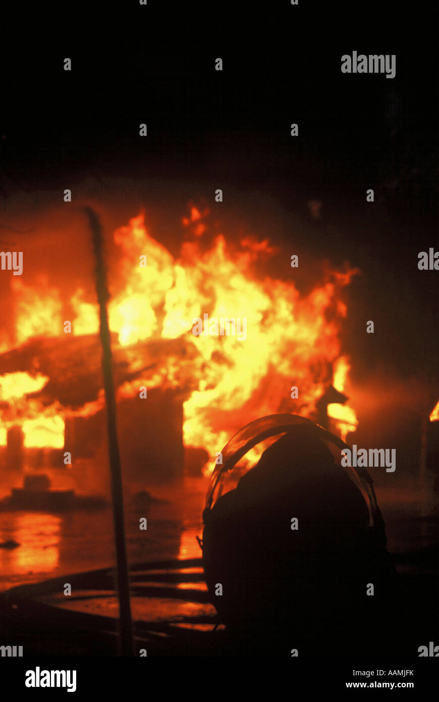 Fire fighter putting water on a house fire Stock Photo - Alamy