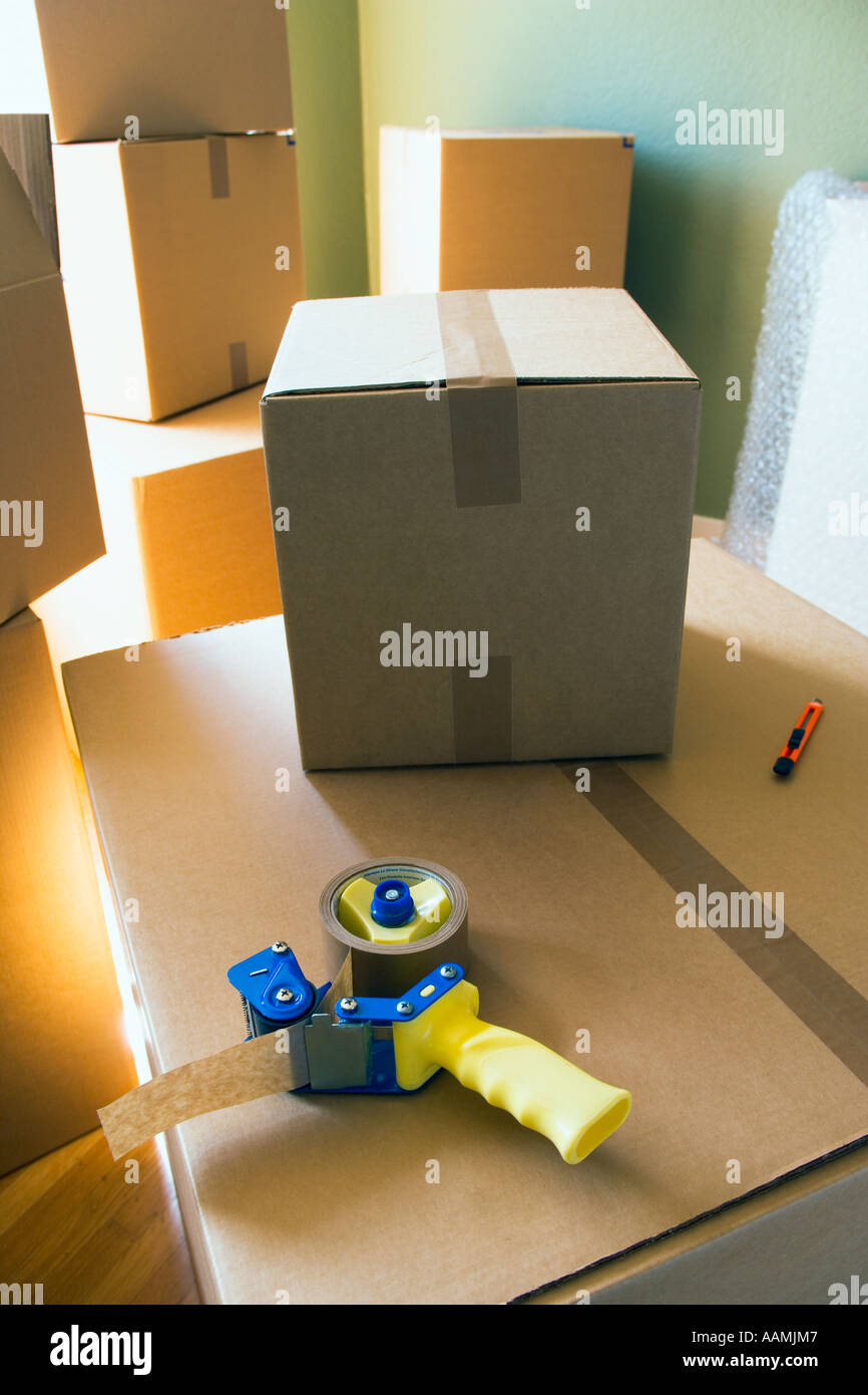 Still life of moving boxes and tape dispenser Stock Photo - Alamy