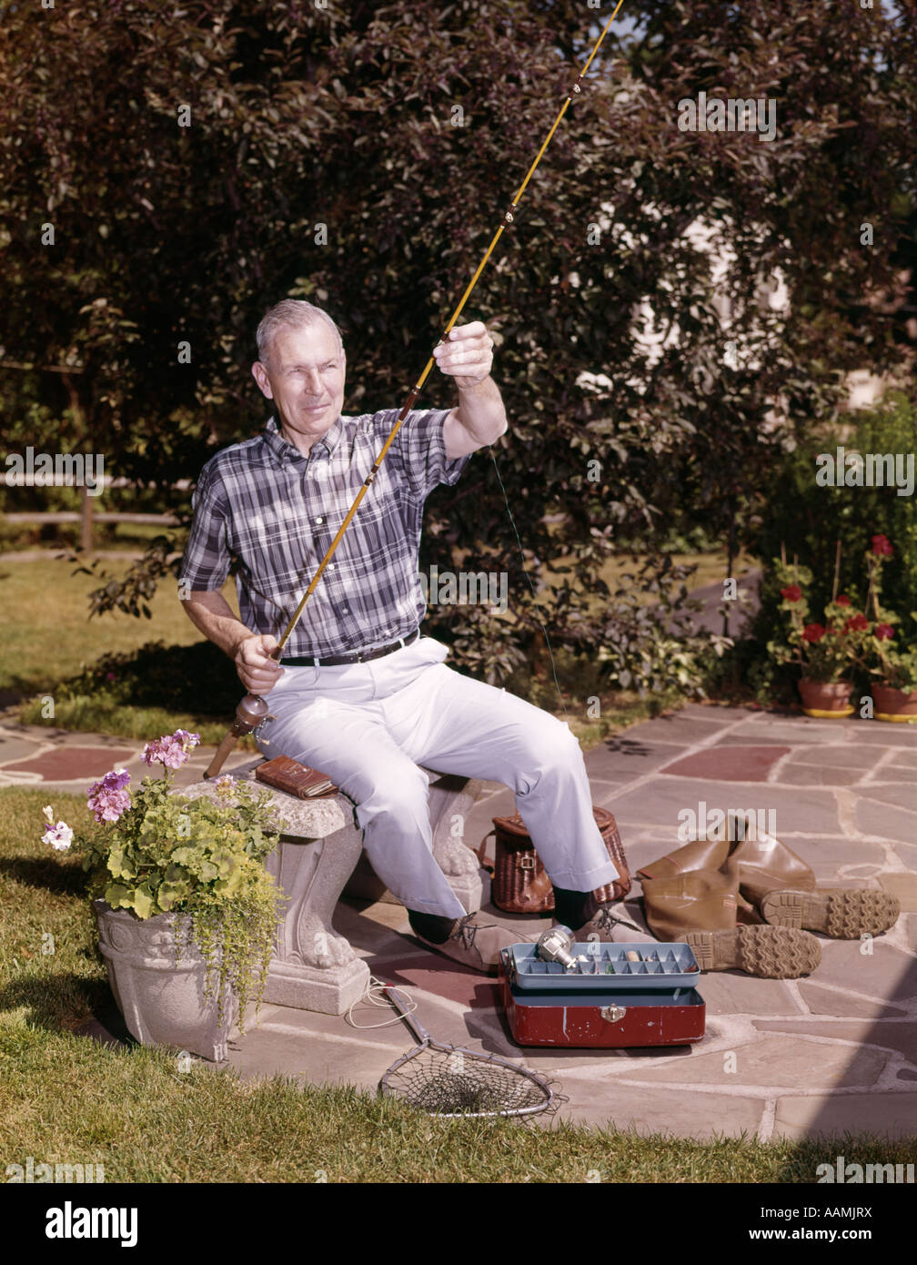 1960s OLDER MAN SITTING IN BACKYARD WITH FISHING ROD AND GEAR TACKLE ...