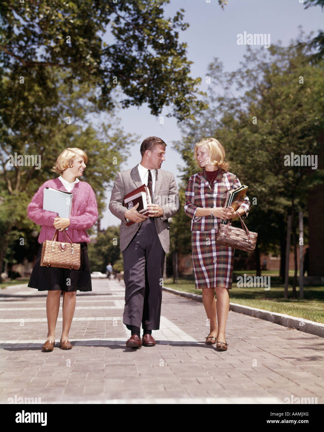1960s 3 STUDENTS WALKING ON CAMPUS CARRY BOOKS BOY IN SUIT & TIE 2 ...