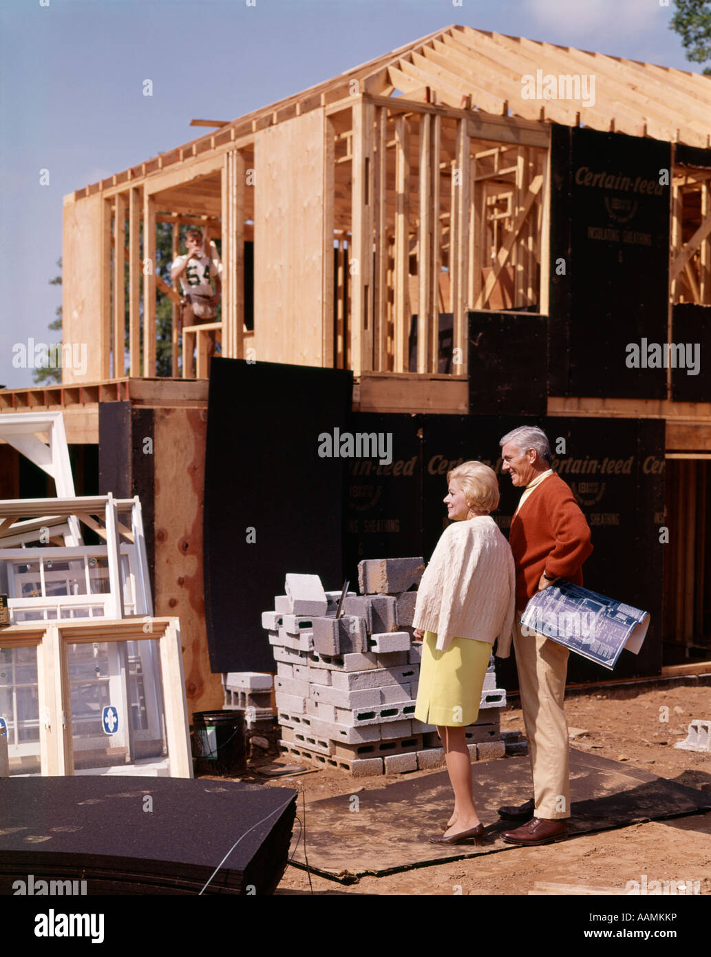 1960s COUPLE LOOKING AT NEW HOME UNDER CONSTRUCTION BUILDING MAN WOMAN ...