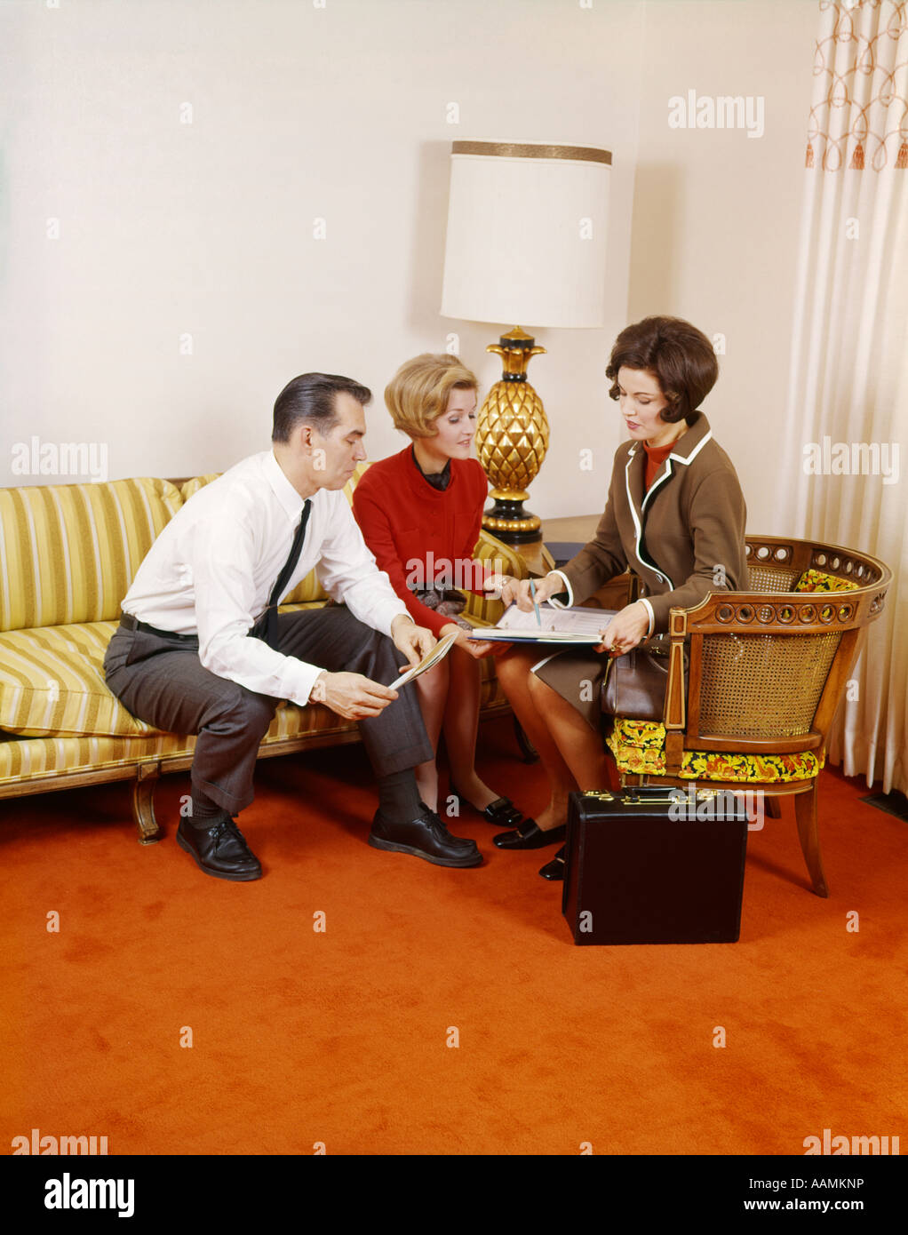 1970s MAN AND WOMAN CONSULTING WITH WOMAN WITH ATTACHE CASE AND ...