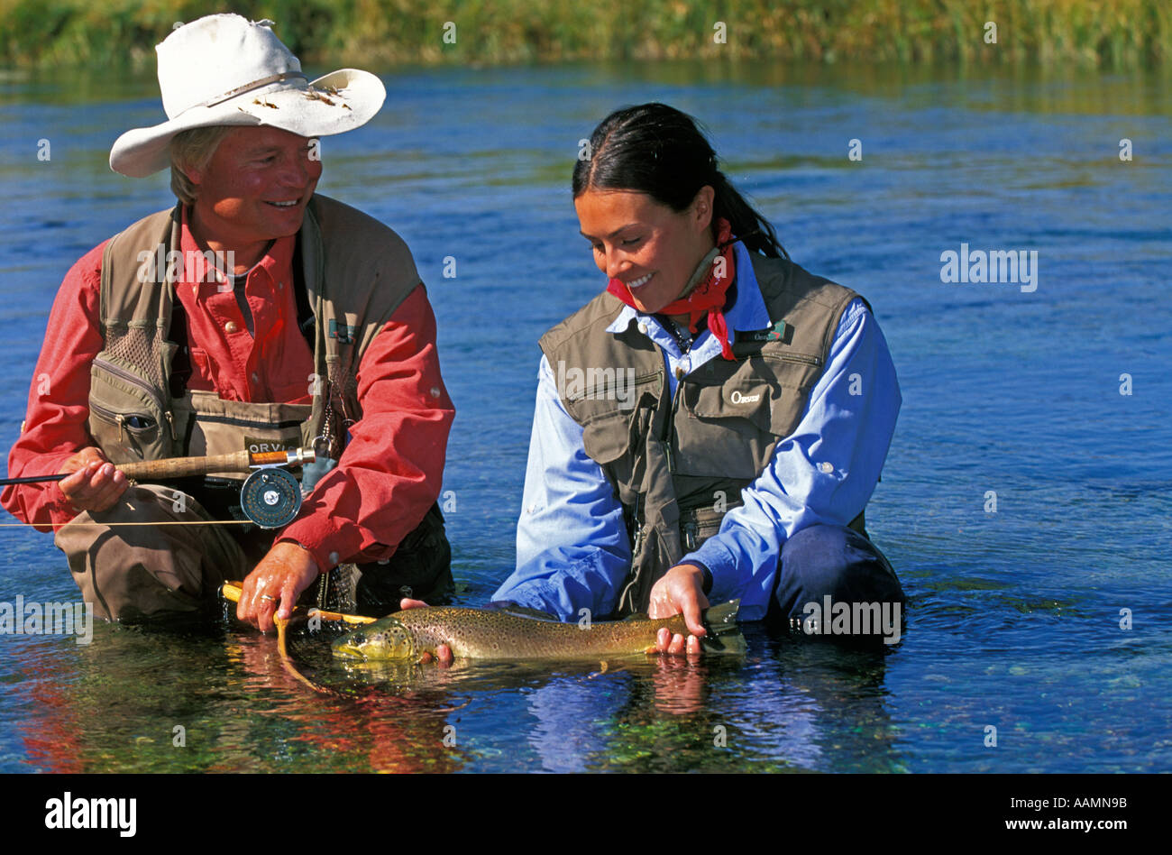 IDAHO Guide and woman fisherman releasing Brown Trout Siver Creek Sun ...