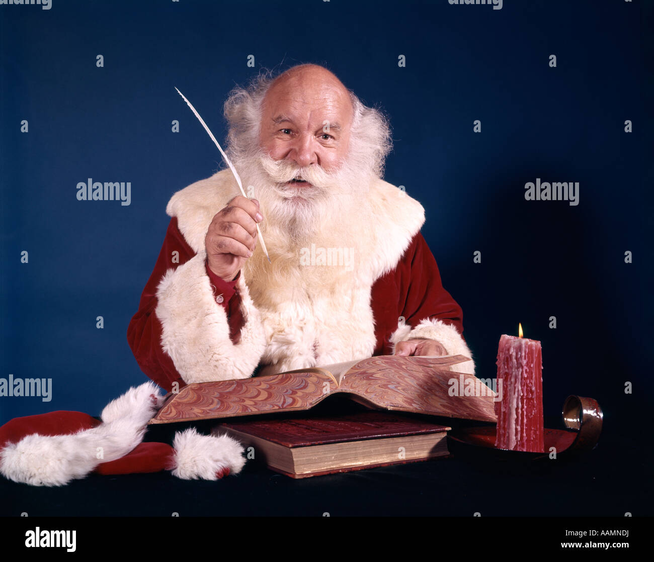 1960s SANTA SITTING AT DESK WITH OPEN BOOK MAKING A LIST WITH QUILL PEN ...
