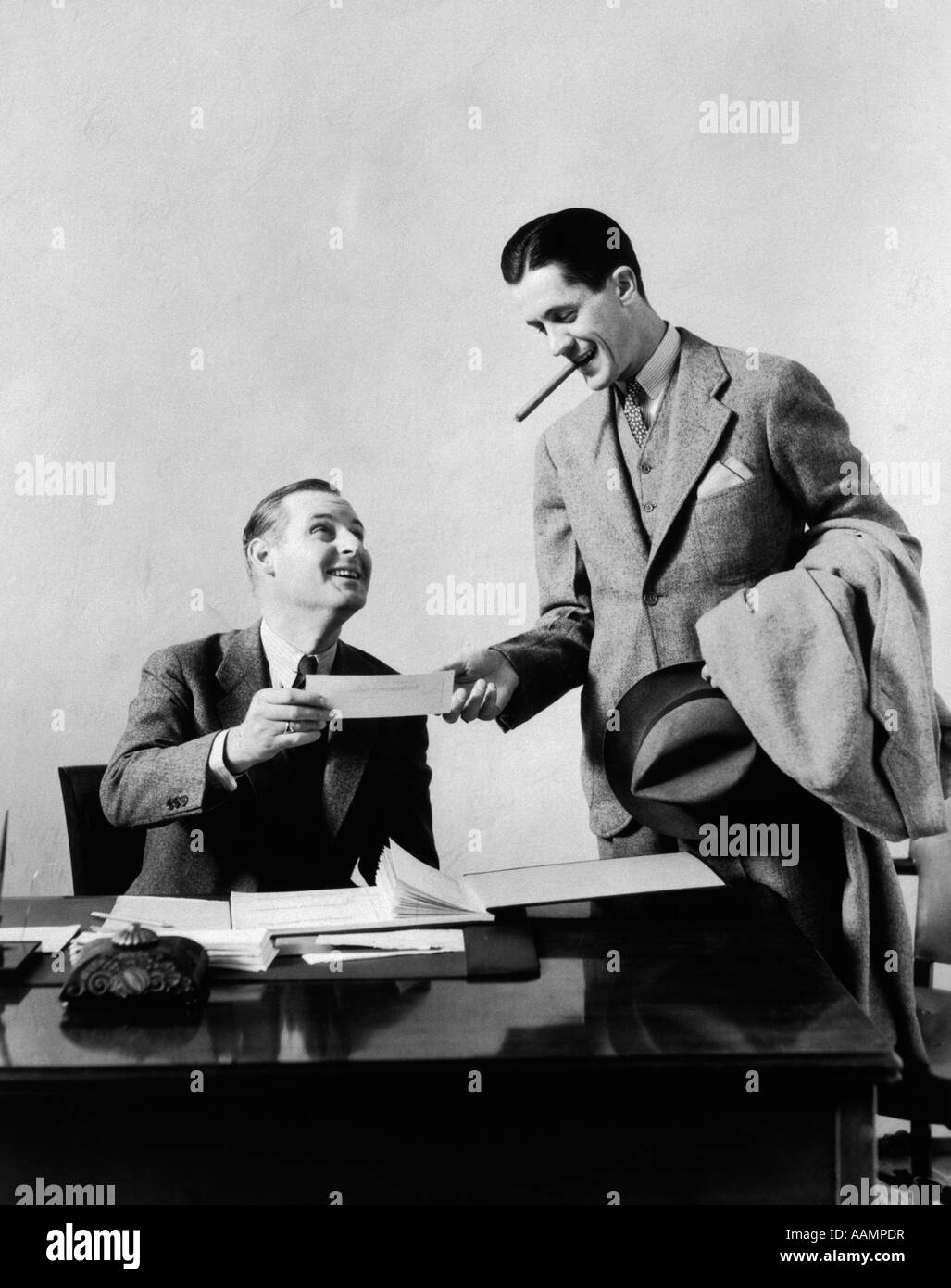 1930s TWO MEN AT DESK IN OFFICE ONE MAN WITH CIGAR EXCHANGING PAPER ...
