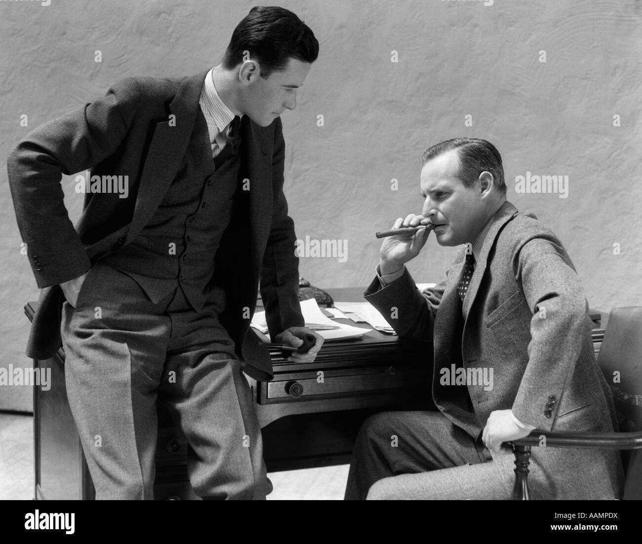 1930s TWO MEN AT DESK TALKING ONE MAN SMOKING CIGAR Stock Photo - Alamy