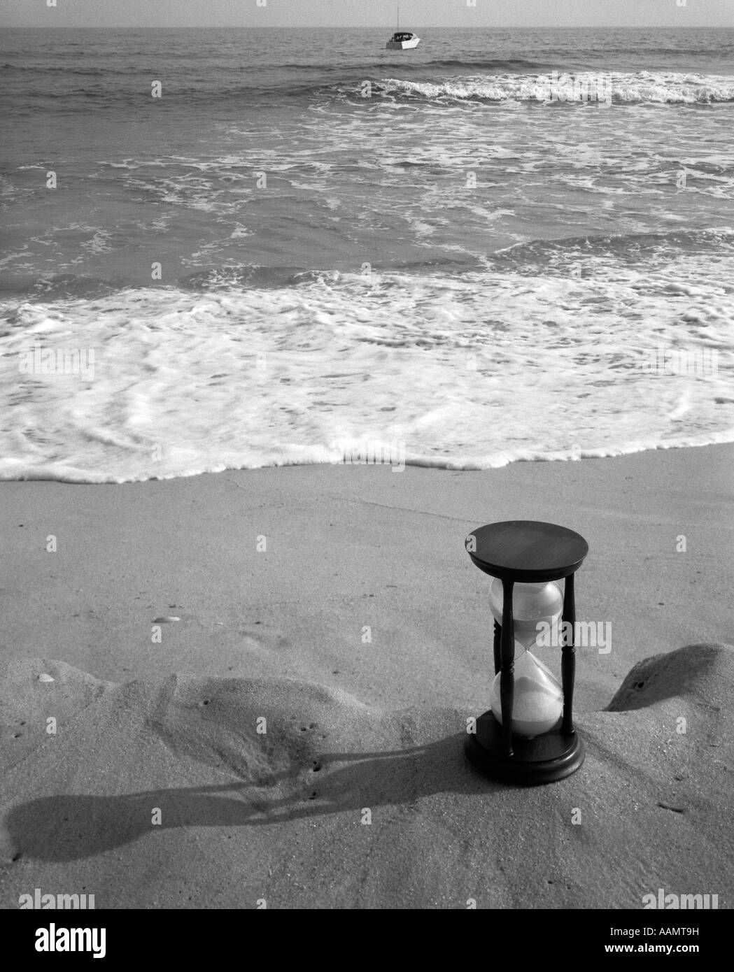 1960s SET-UP OF HOURGLASS ON LEDGE OF SAND WITH WAVES WASHING UP ON ...