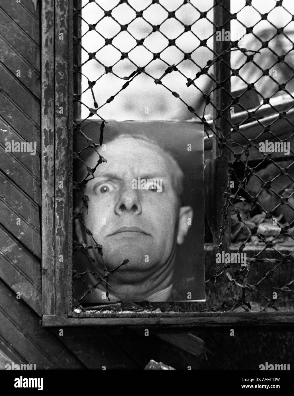 STILL LIFE OF PHOTO OF MAN WITH CRAZED EXPRESSION PLACED IN WINDOW WITH ...