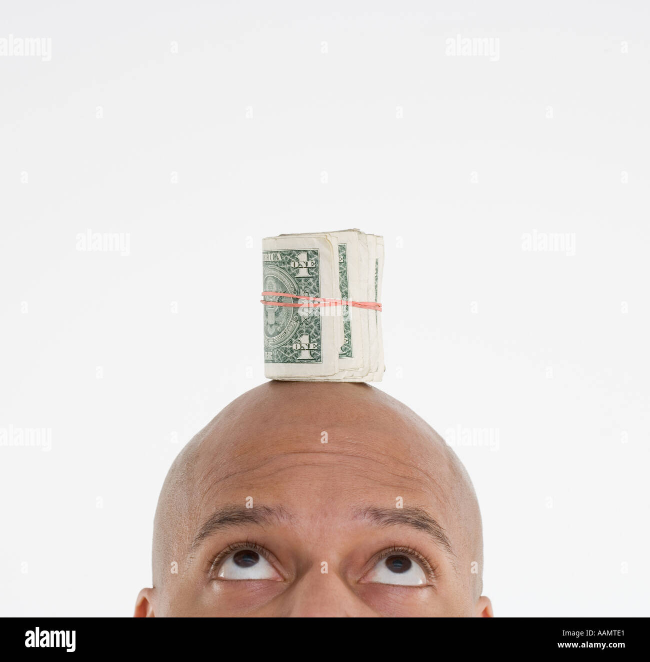 Man with roll of dollar bills on head Stock Photo - Alamy