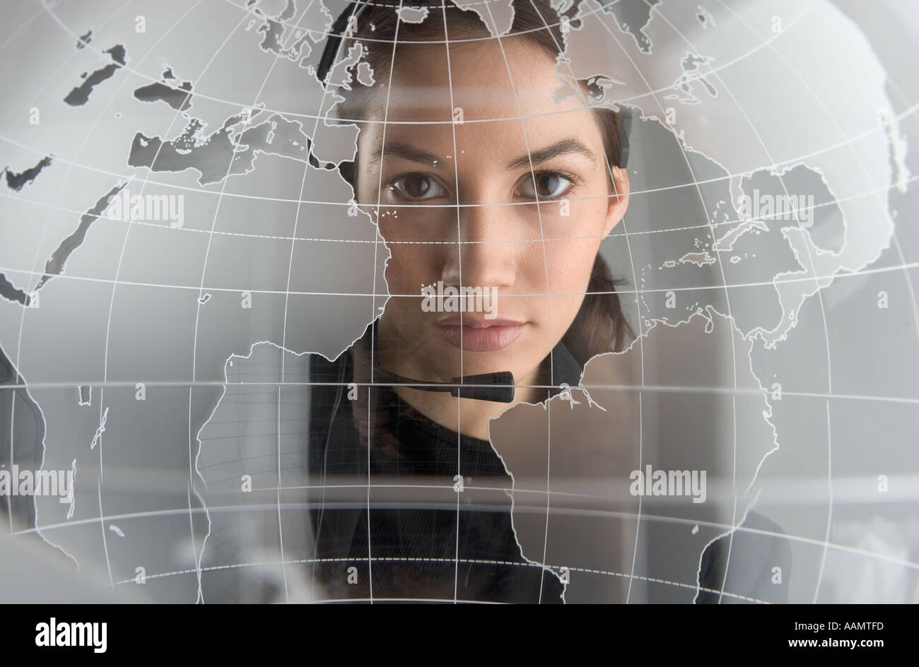 Portrait of woman looking through glass globe Stock Photo - Alamy
