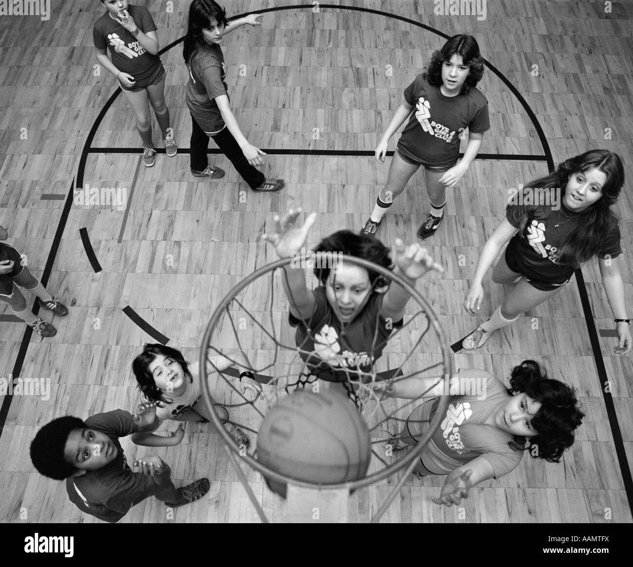 1980s BIRD'S EYE VIEW OF GROUP OF KIDS PLAYING BASKETBALL ONE JUMPING ...
