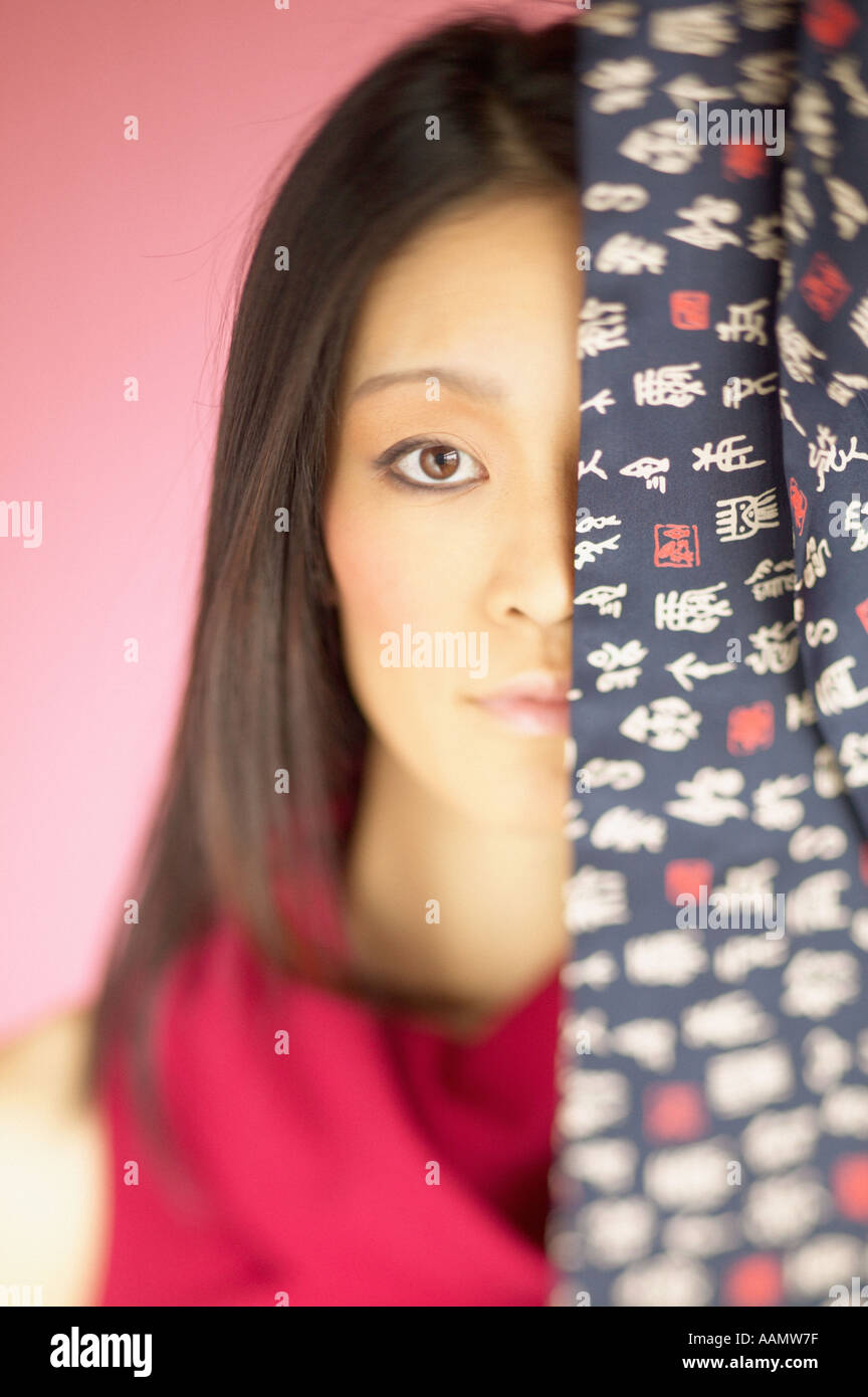 Portrait of woman behind curtain Stock Photo - Alamy