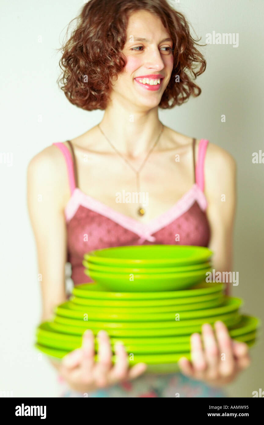 Woman holding stack of dishes Stock Photo - Alamy
