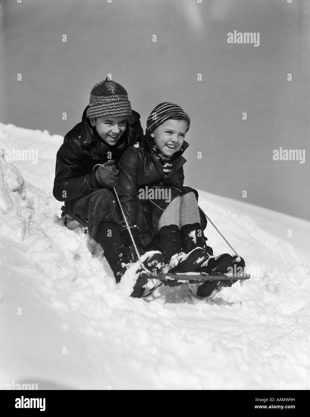 1930s BOY AND GIRL GOING DOWN HILL ON SLED OUTSIDE IN SNOW Stock Photo ...