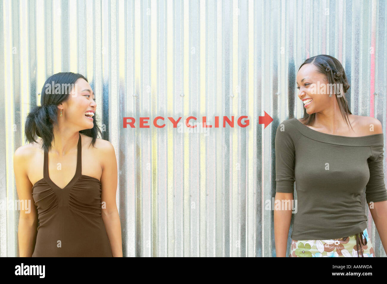 Two female friends standing by recycling sign Stock Photo - Alamy