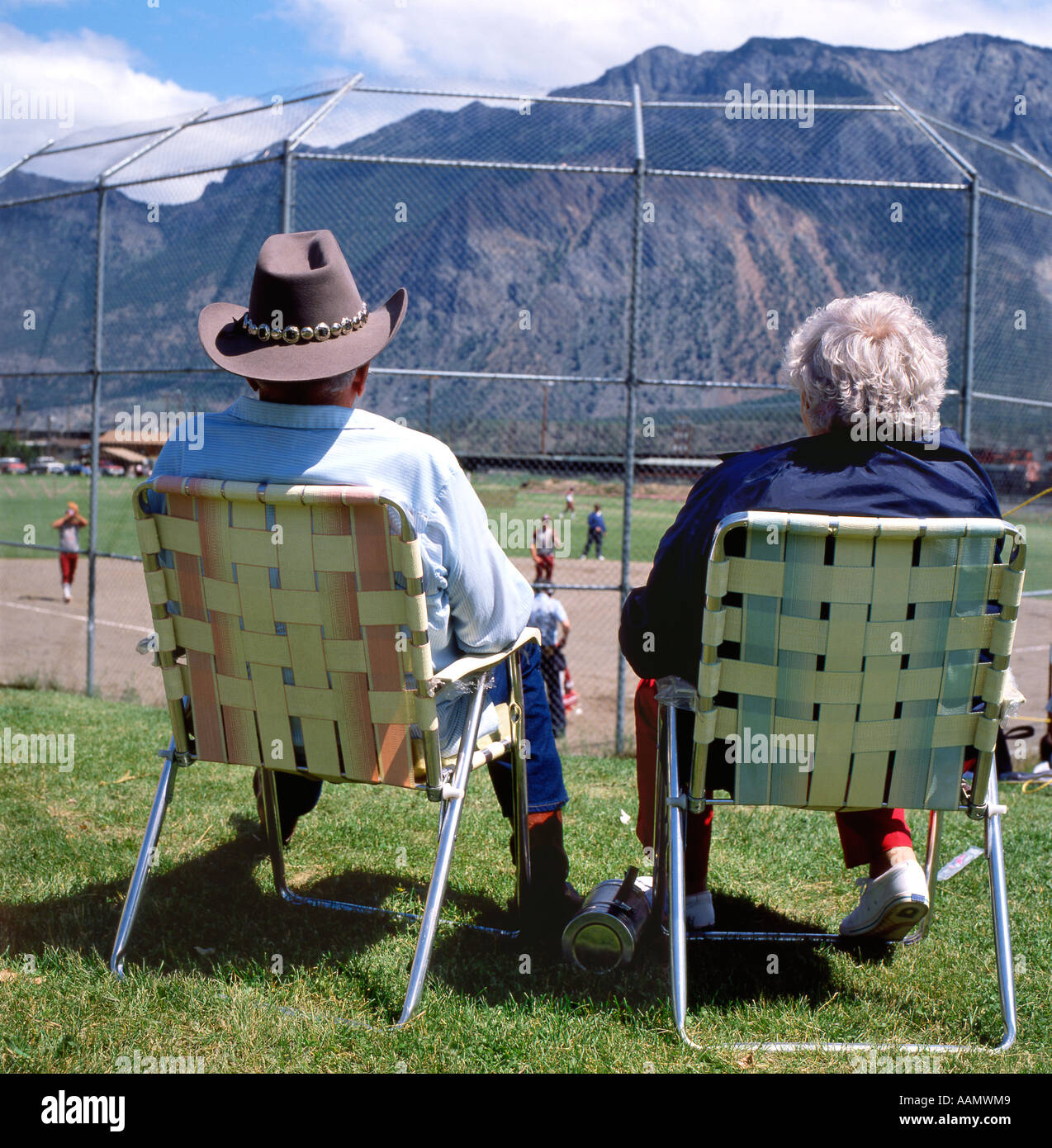 An elderly First Nation couple sitting on deckchairs watching a ...