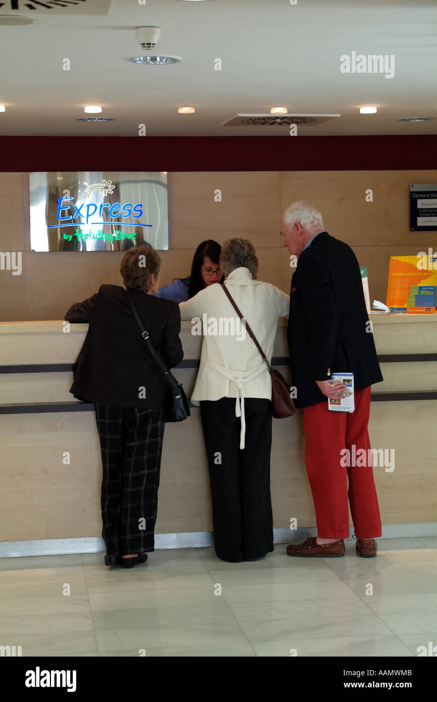 Hotel check in desk reception. Guests signing into the establishment ...