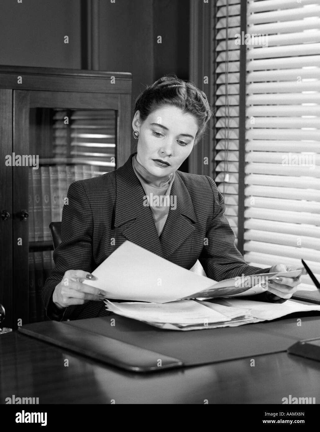 1950s WOMAN BUSINESS DESK READING PAPERWORK PEN BOOKCASE Stock Photo ...