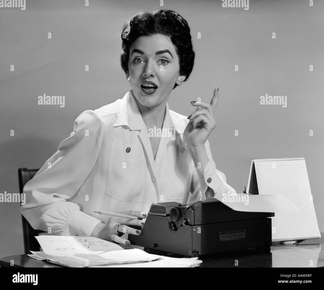 1950s WOMAN DESK SECRETARY TYPEWRITER FINGER IDEA TALK Stock Photo - Alamy