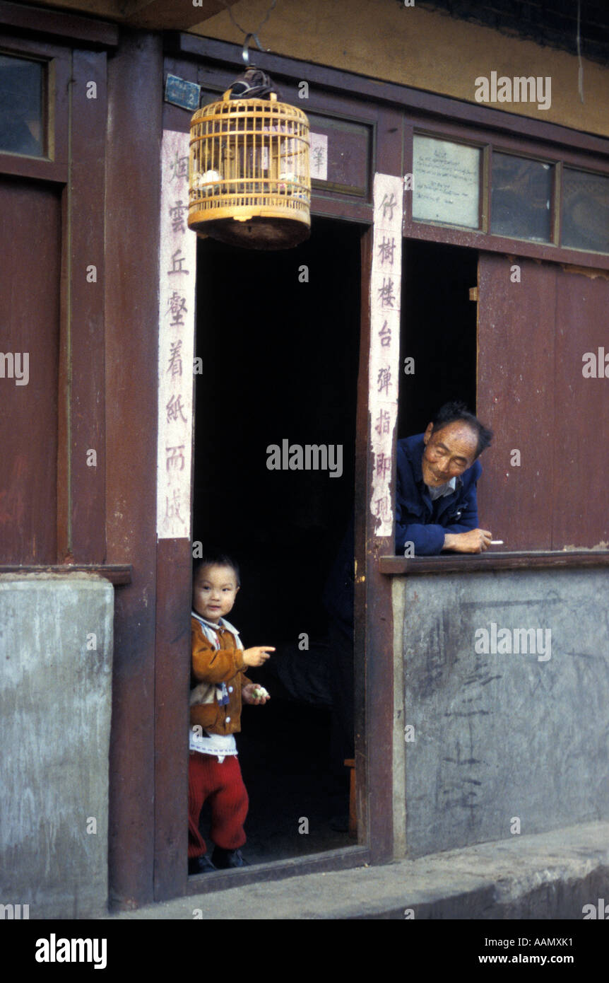 Young Chinese child with grandfather in doorway, Lijiang, Yunnan, China ...