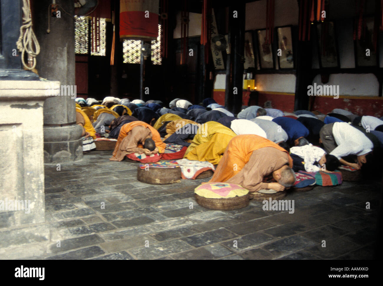Chinese Buddhist monks prostrate at prayer inside ancient temple ...