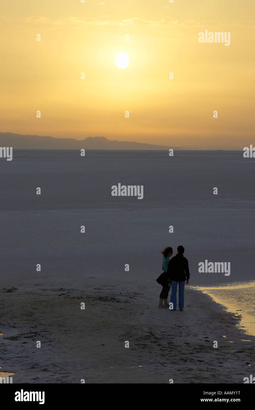 lone tourist couple standing watching the sun rise over chott el djerid ...