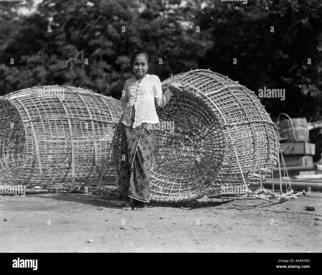 1930s SMALL NATIVE WOMAN STANDING BY TWO LARGE JAPANESE FISH TRAPS ...
