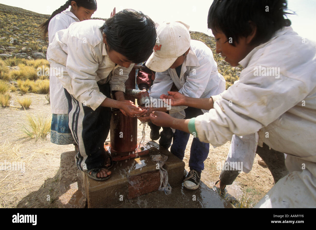 School children wash their hands after a ceramics class by a well ...