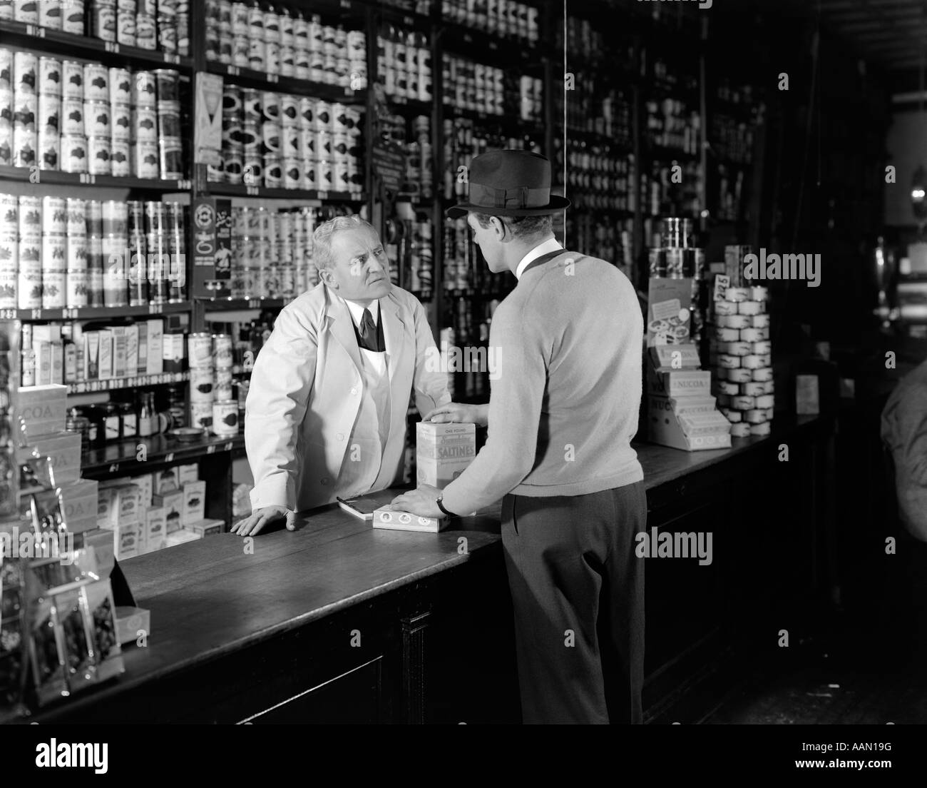 1930s 1940s TWO MEN CUSTOMER AND CLERK IN GENERAL STORE TALKING OVER ...