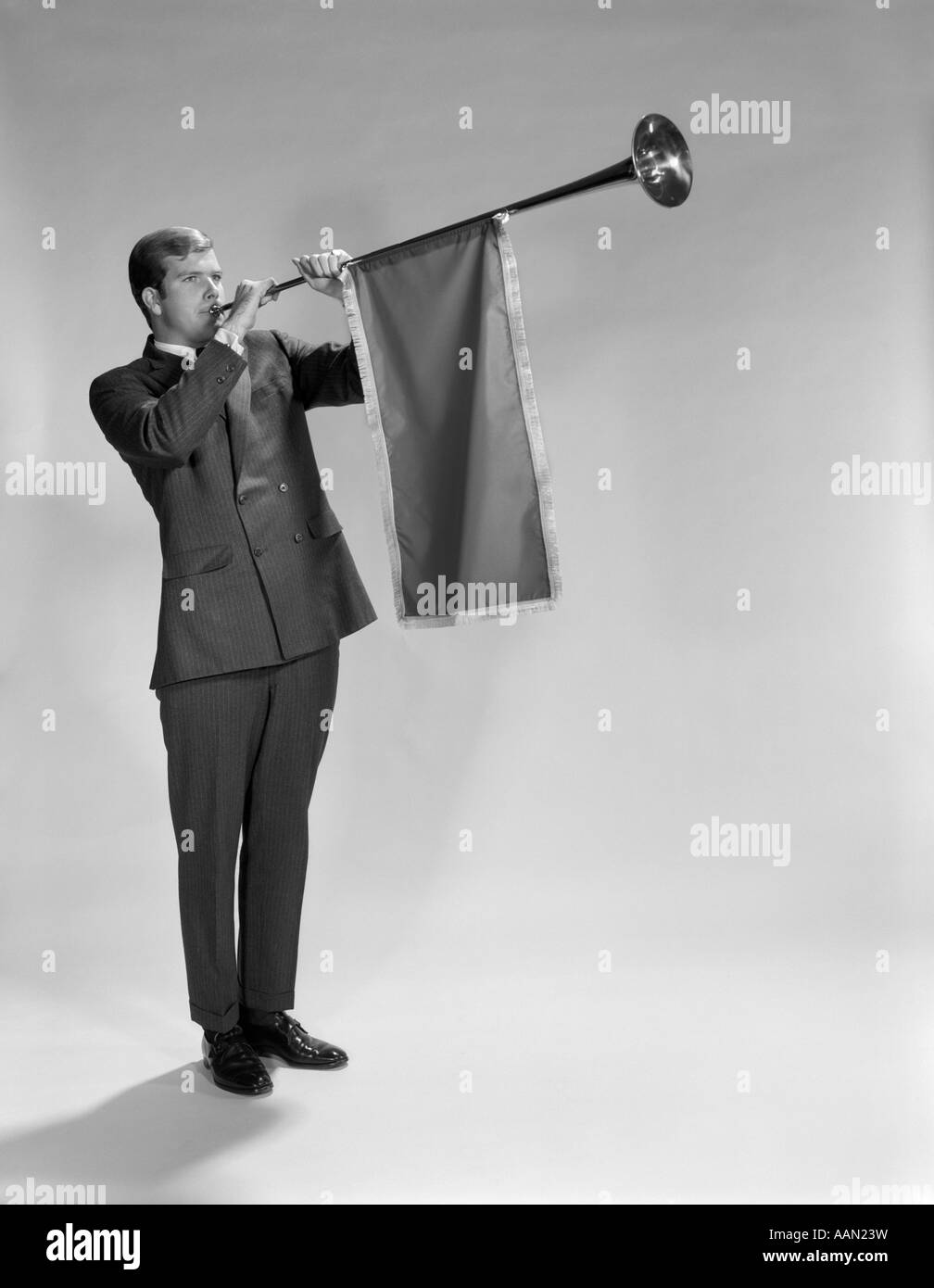 1960s YOUNG MAN STANDING BLOWING HERALD'S HORN Stock Photo - Alamy