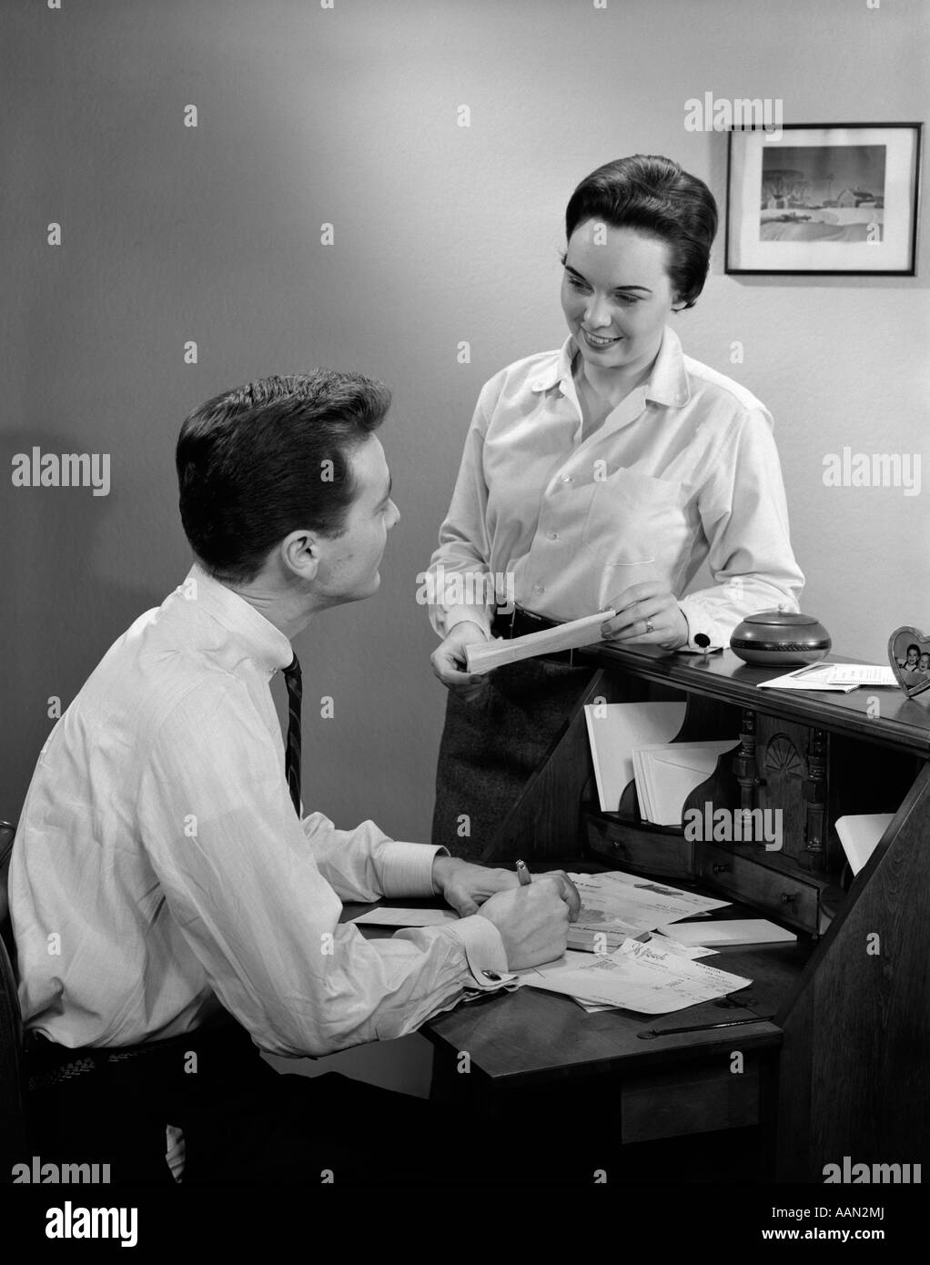 1950s COUPLE AT DESK GOING OVER CHECKBOOK PAYING BILLS Stock Photo - Alamy
