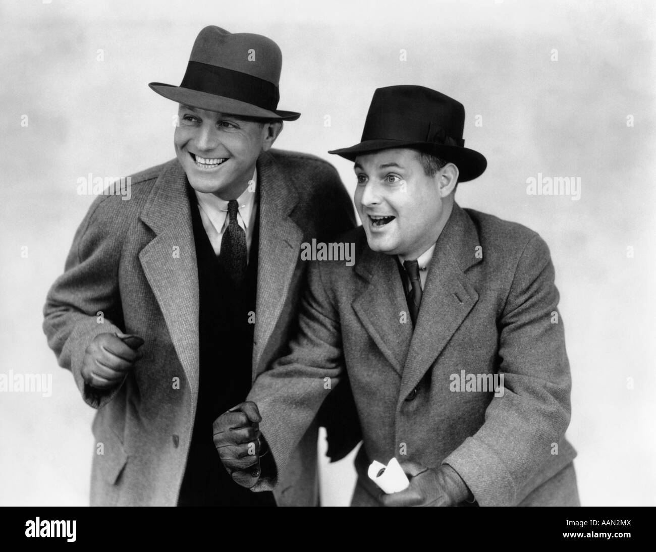 1930s TWO MEN WEARING HATS COATS AND GLOVES CHEERING FOR SPORTS EVENT ...
