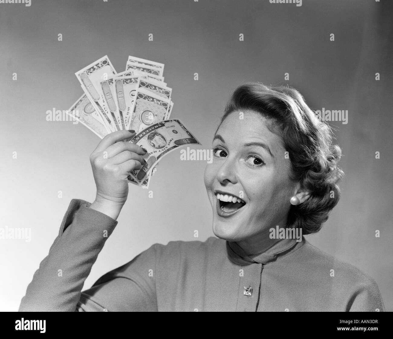 1950s PORTRAIT OF WOMAN HOLDING UP MONEY WITH EXAGGERATED SMILE LOOKING ...