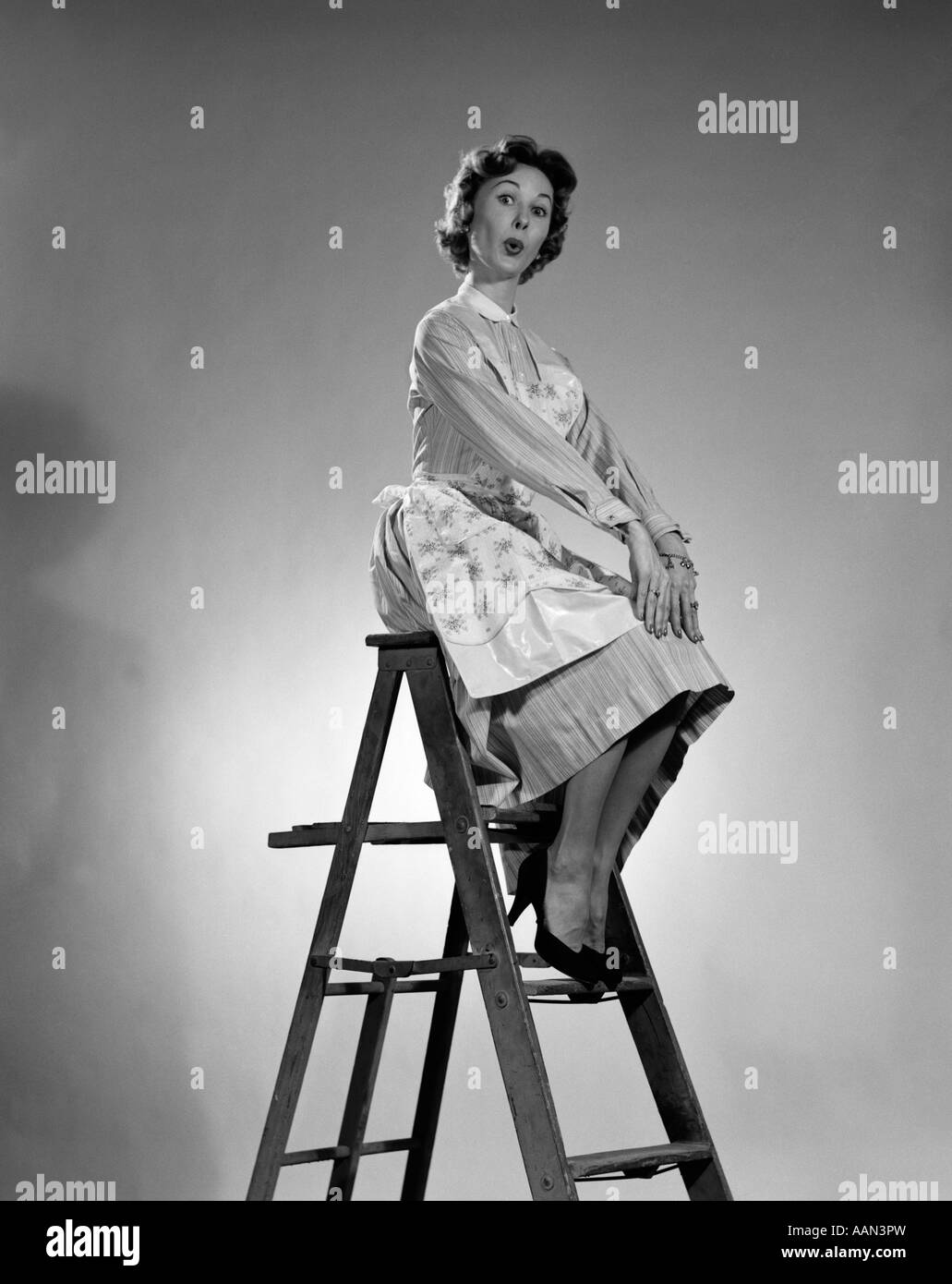 1950s WOMAN IN APRON WITH EXAGGERATED EXPRESSION SITTING ON TOP OF A ...