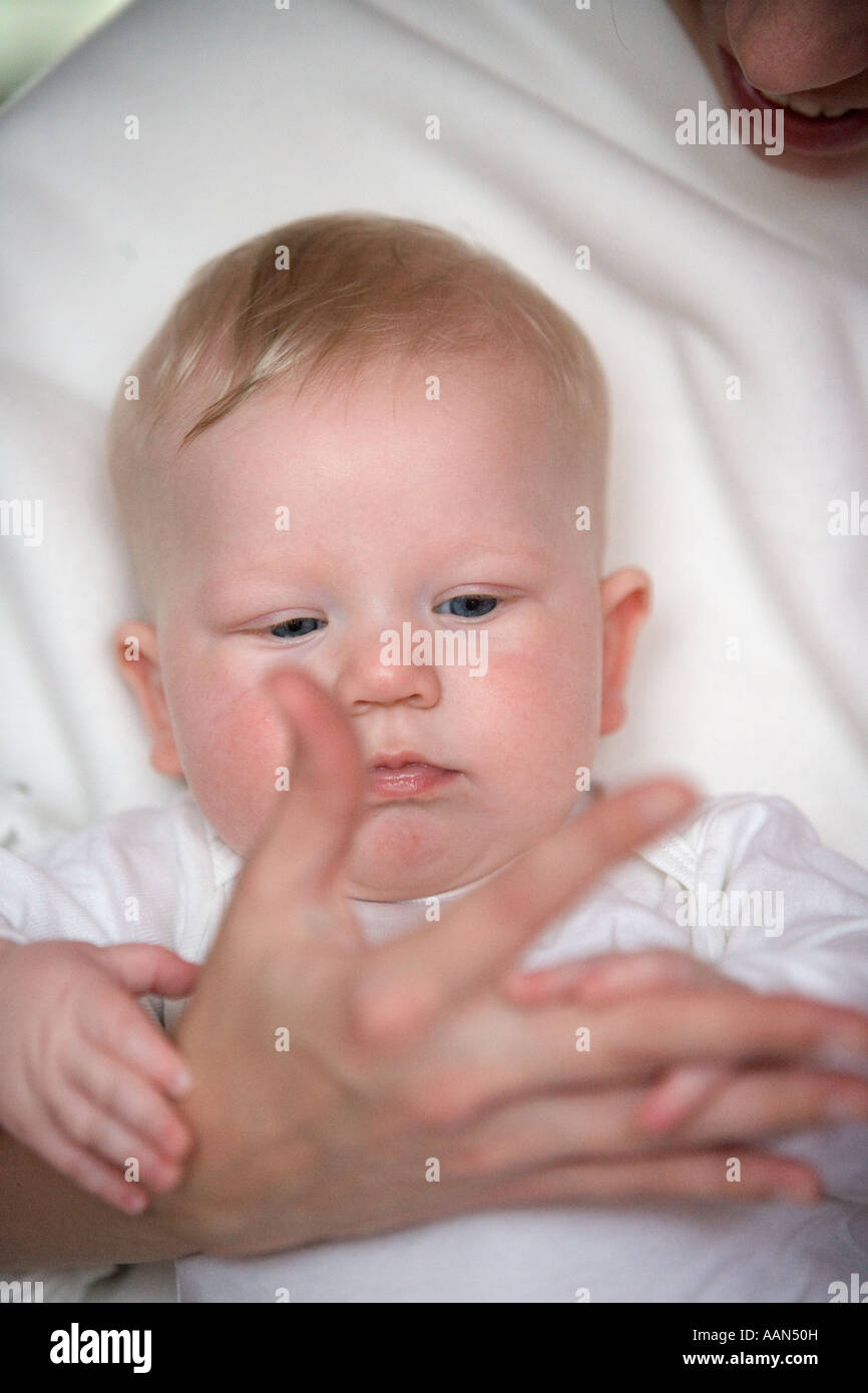 Baby playing with mothers hand Stock Photo - Alamy