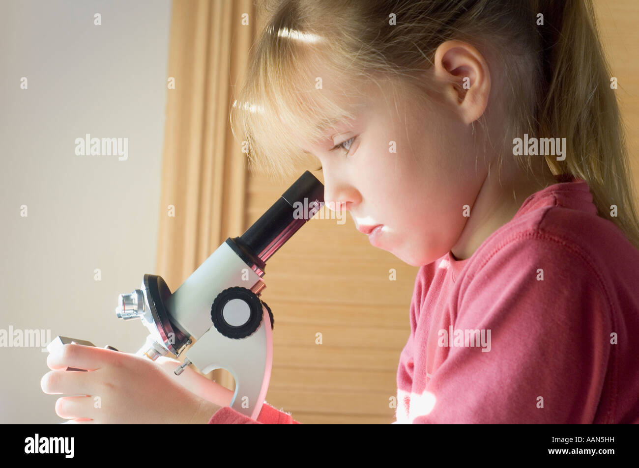 Girl playing with a microscope Stock Photo - Alamy