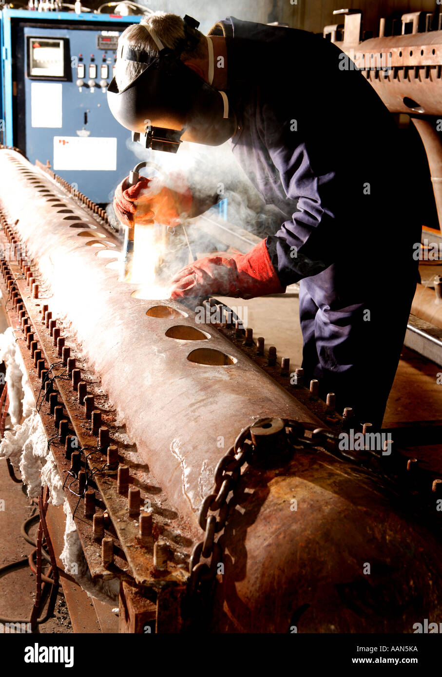 Welder welding heavy machinery used in the boiler plant of a ship Stock ...