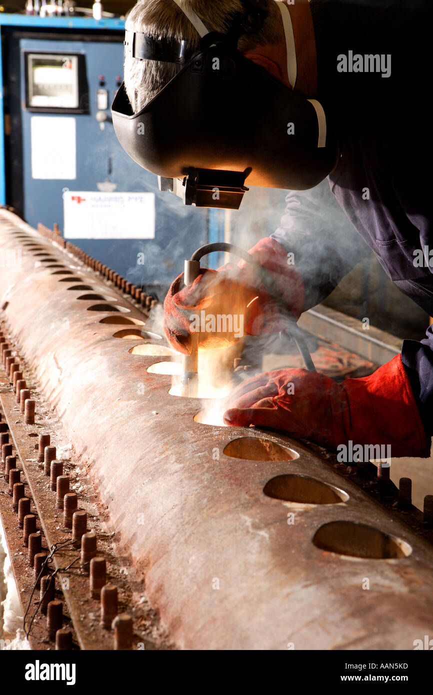 Welder welding heavy machinery used in the boiler plant of a ship Stock ...