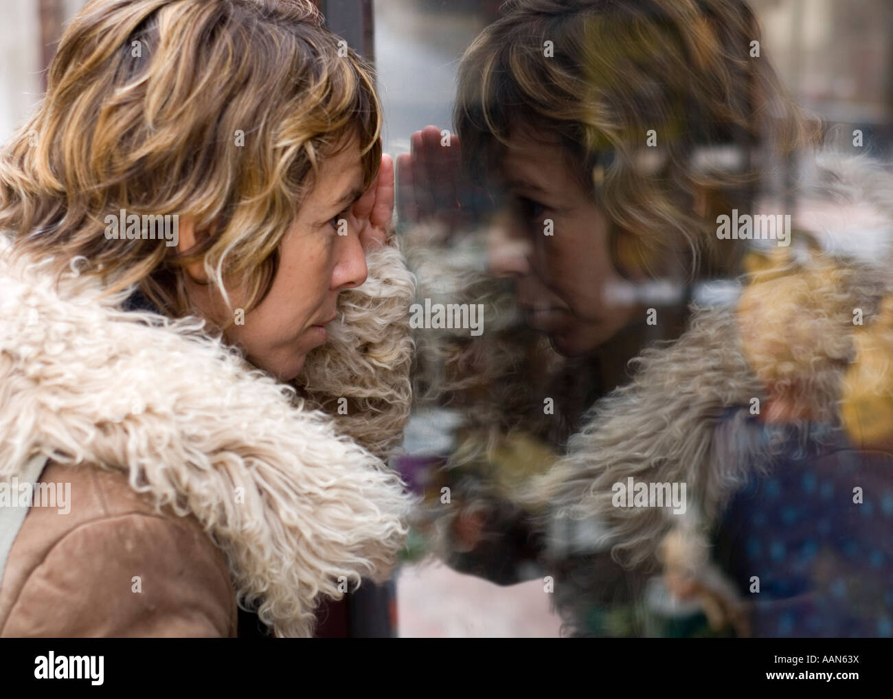 Woman looking into shop window Stock Photo - Alamy