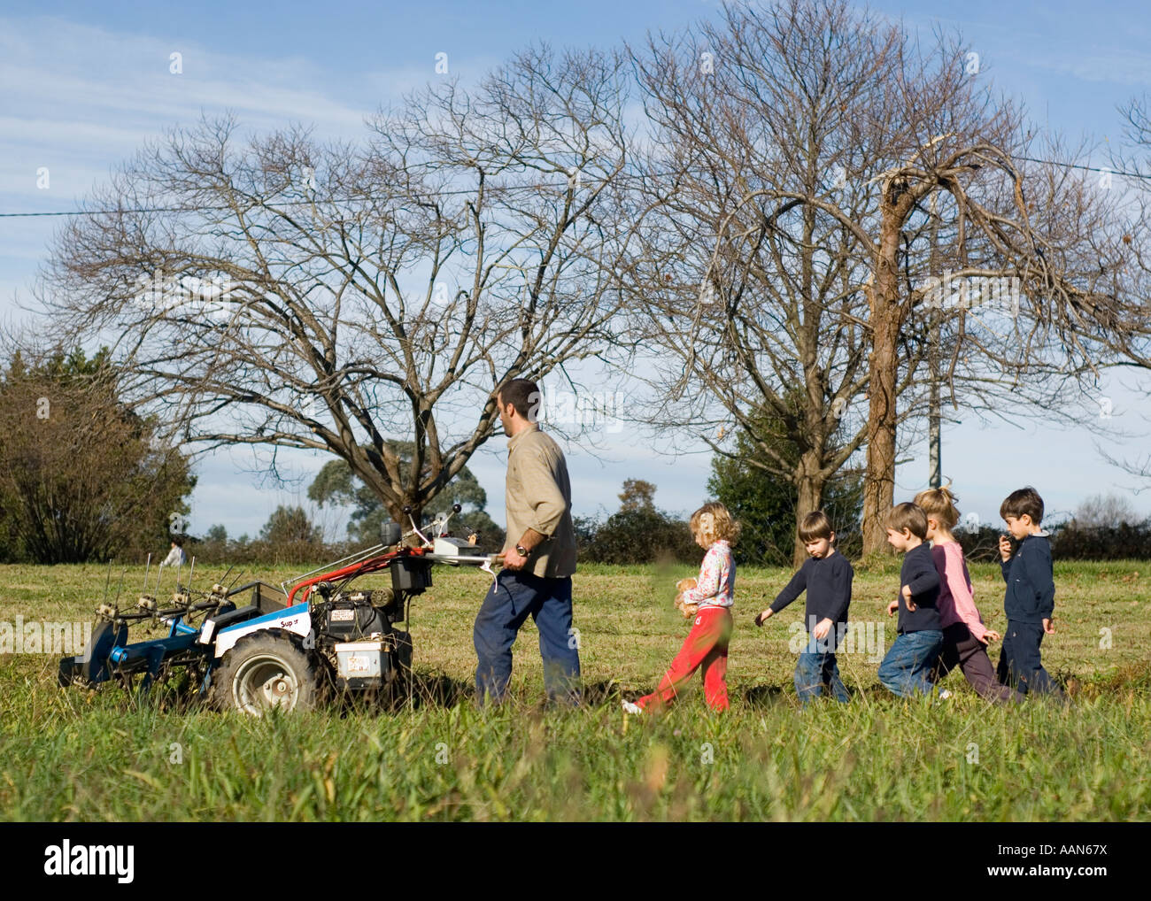 kids following the gardener Stock Photo - Alamy