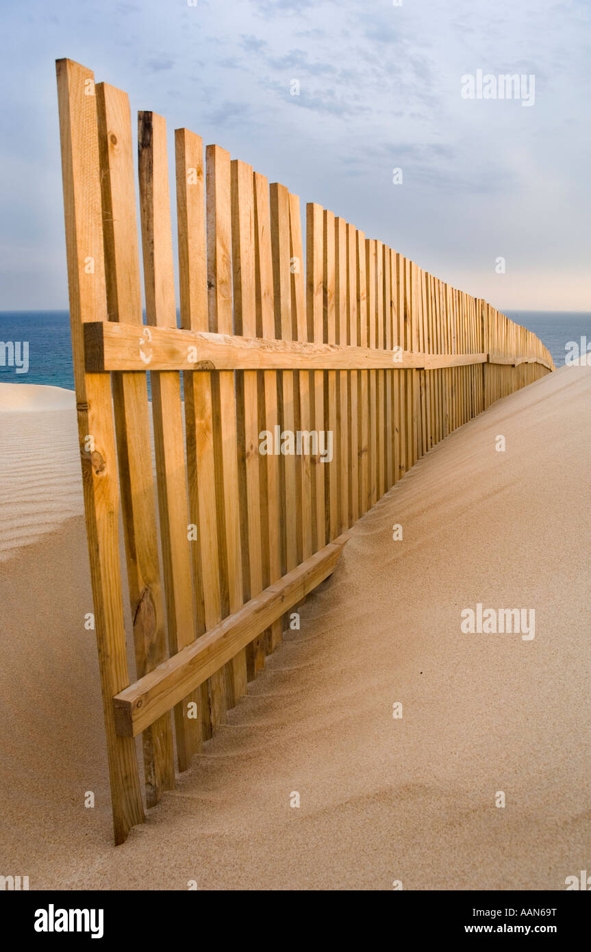 a warm landscape photograph of wooden fence and sand dune in tarifa ...