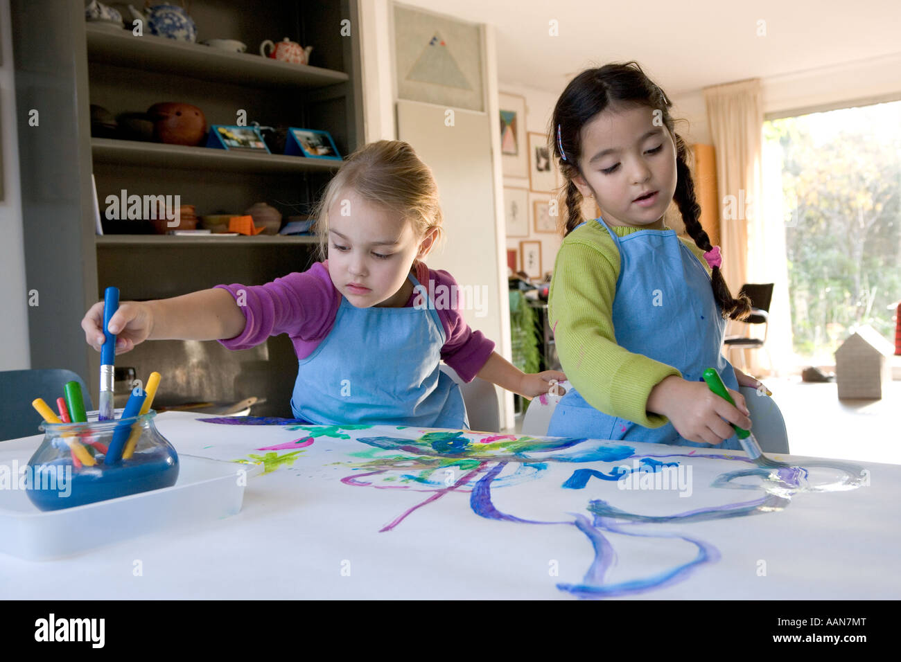 Two little girls are making a painting Stock Photo - Alamy
