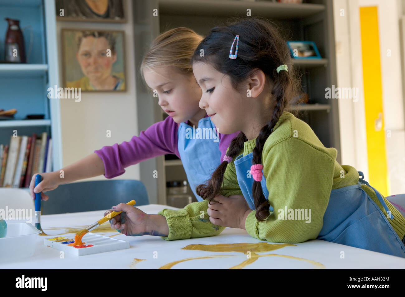 Two little girls are making a painting Stock Photo - Alamy