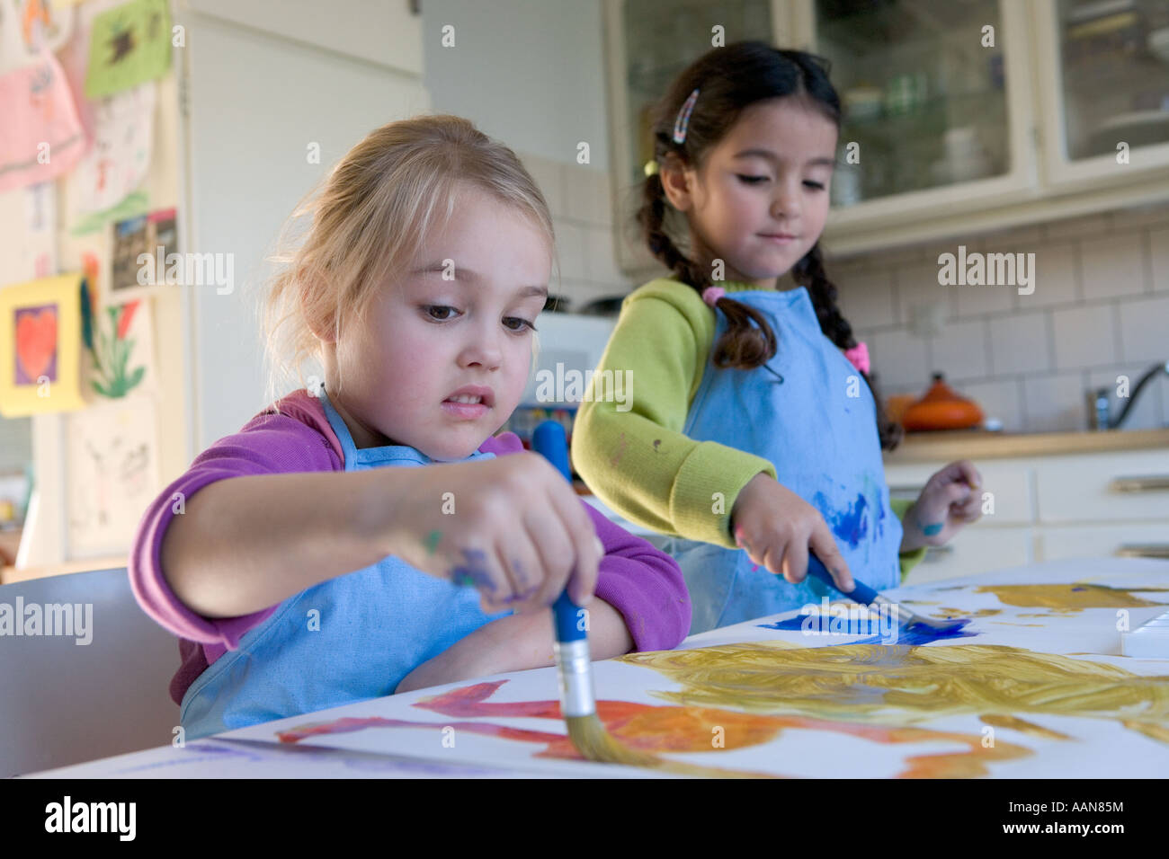 Two little girls are making a painting Stock Photo - Alamy