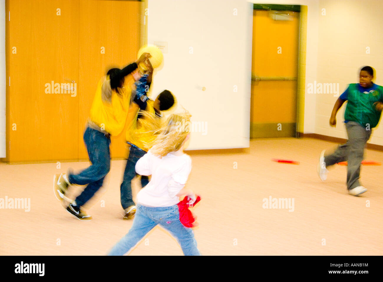 Blurred kids ages 8 thru 12 playing indoor capture the ball in after ...