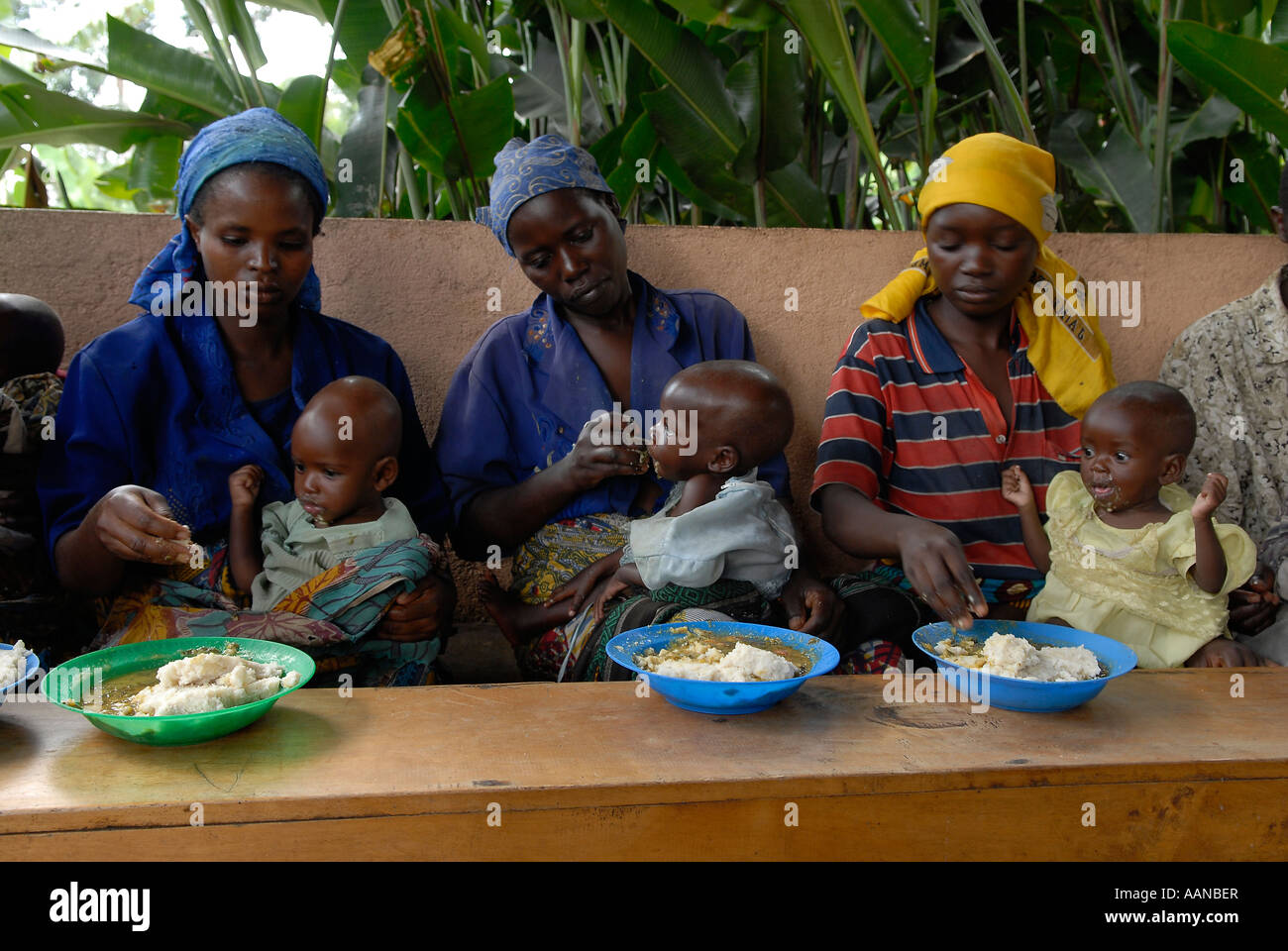 Displaced Congolese women eat with their children mashed cassava at a ...