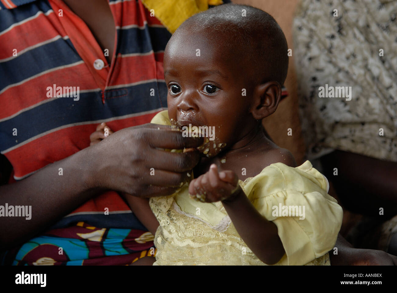 Displaced Congolese woman feeds her daughter mashed cassava at a ...