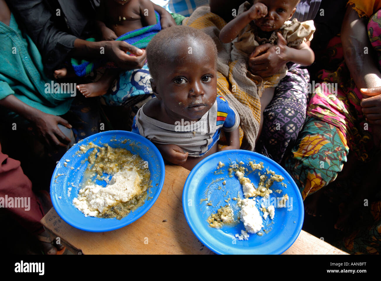 Displaced Congolese children eat mashed cassava with their hands at a ...