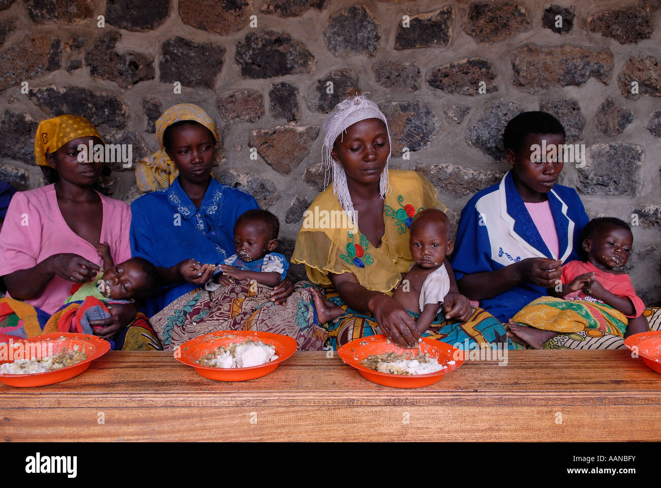 Displaced Congolese women eat with their children mashed cassava at a ...