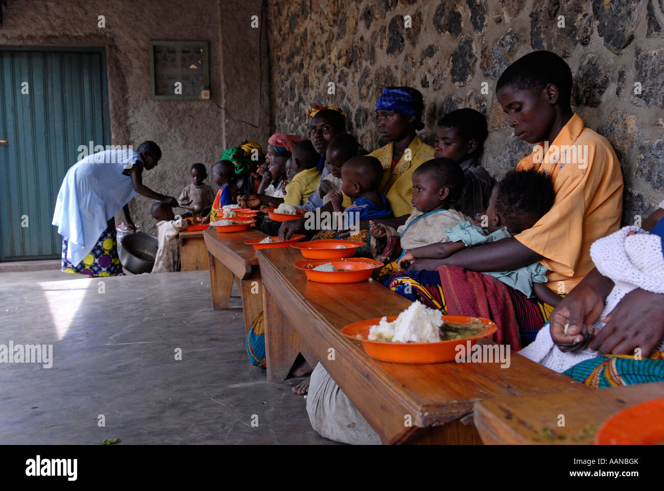 Displaced Congolese women eat with their children mashed cassava at a ...
